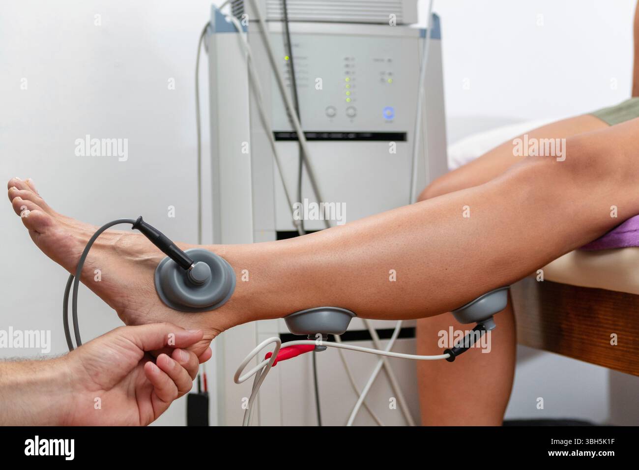 Physical therapist applies vacuum therapy to a patients ankle to ...