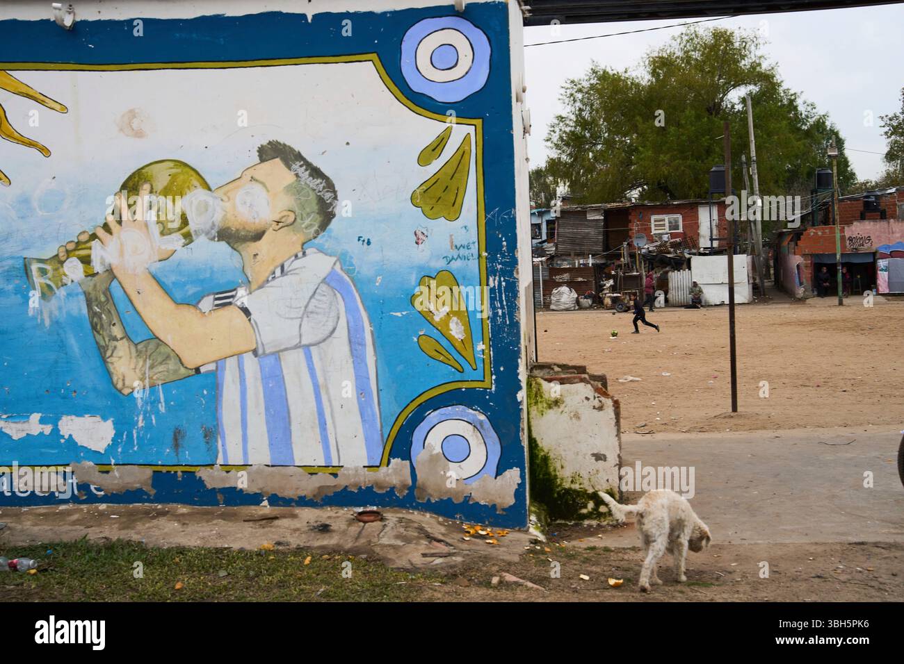 A boy plays with a ball near a painting depicting Argentinian football ...
