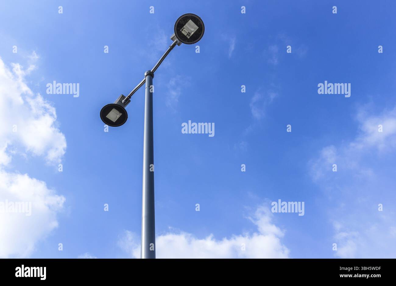 Modern electric street light pole over blue sky with clouds Stock Photo ...