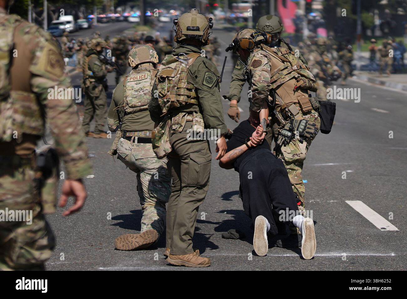 Police detain a man during a protest in the Paramount section of Los ...