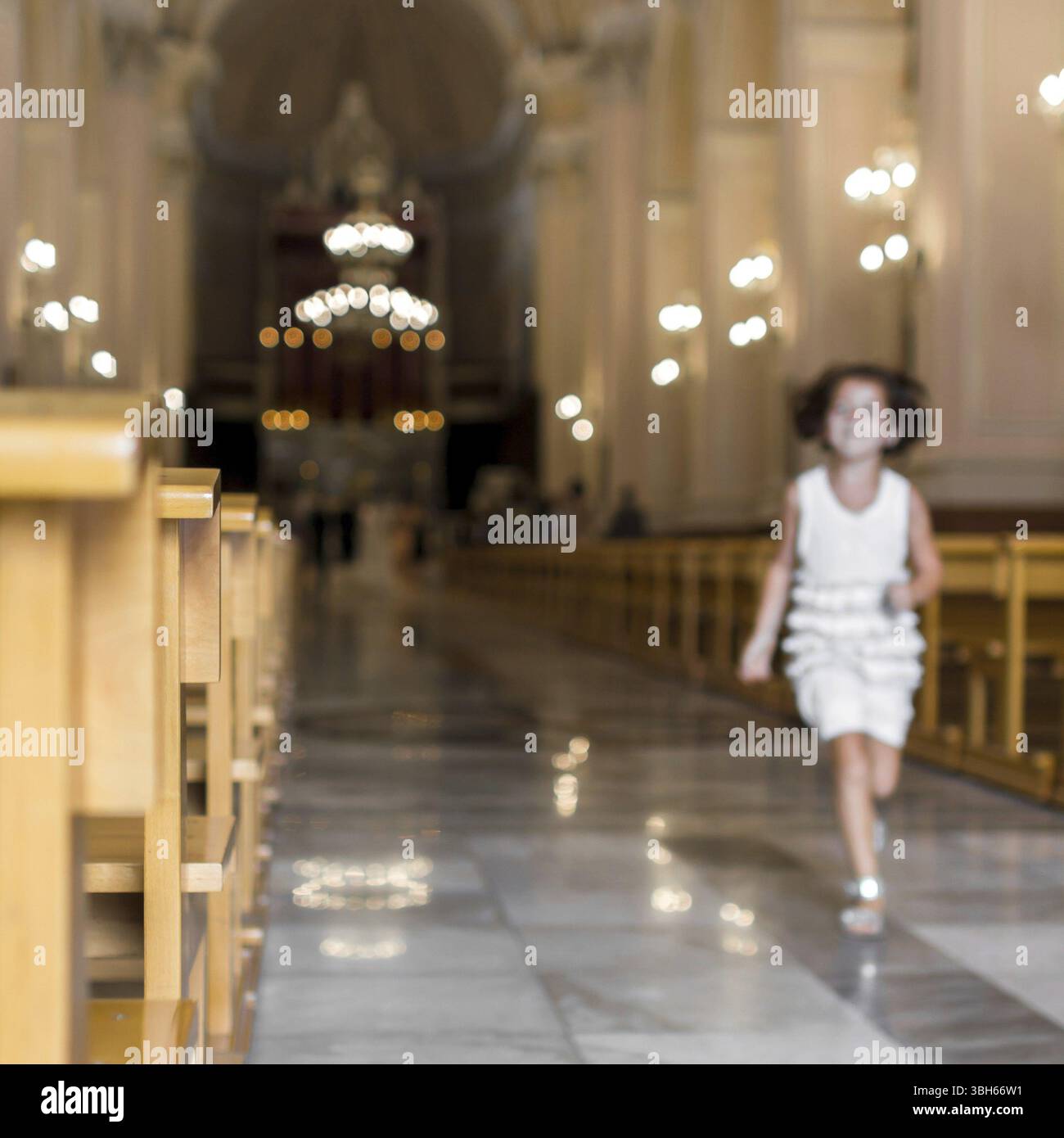 A little girl runs to church, heading for the altar. Defocused blurry ...