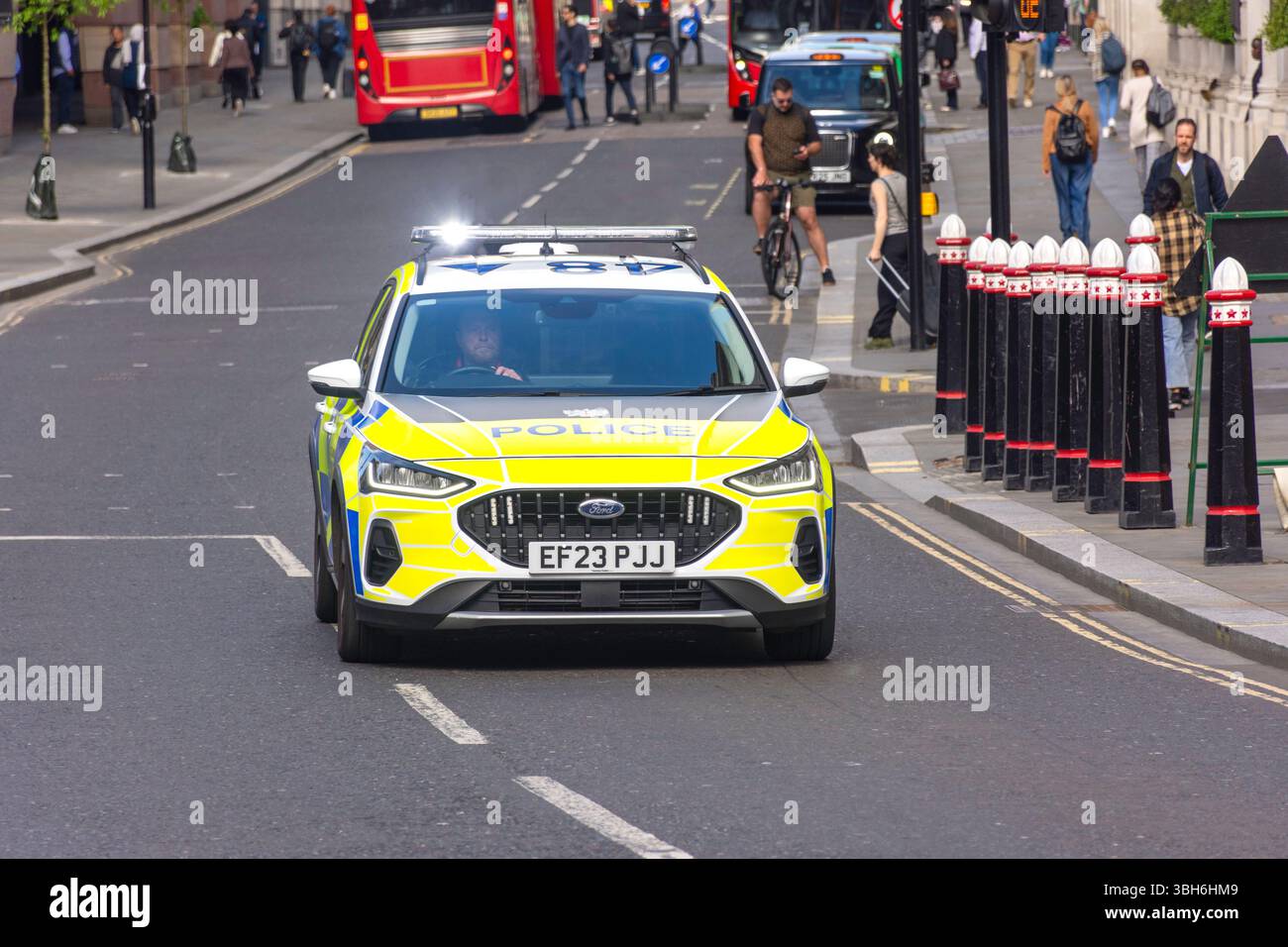 Police car on call with lights and siren, Poultry, City of London ...
