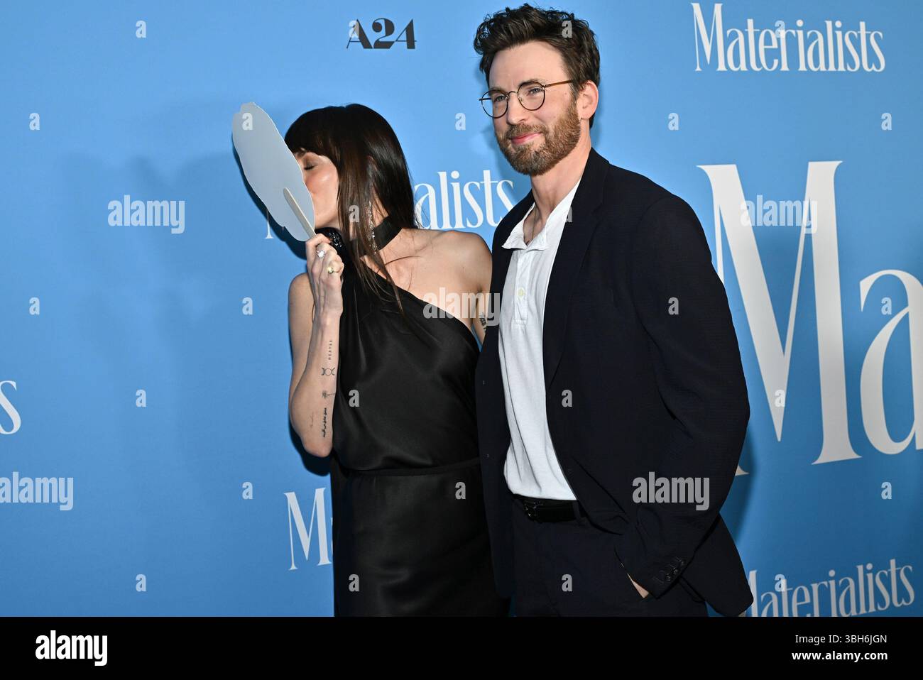 Dakota Johnson, left, and Chris Evans pose with a Pedro Pascal head ...