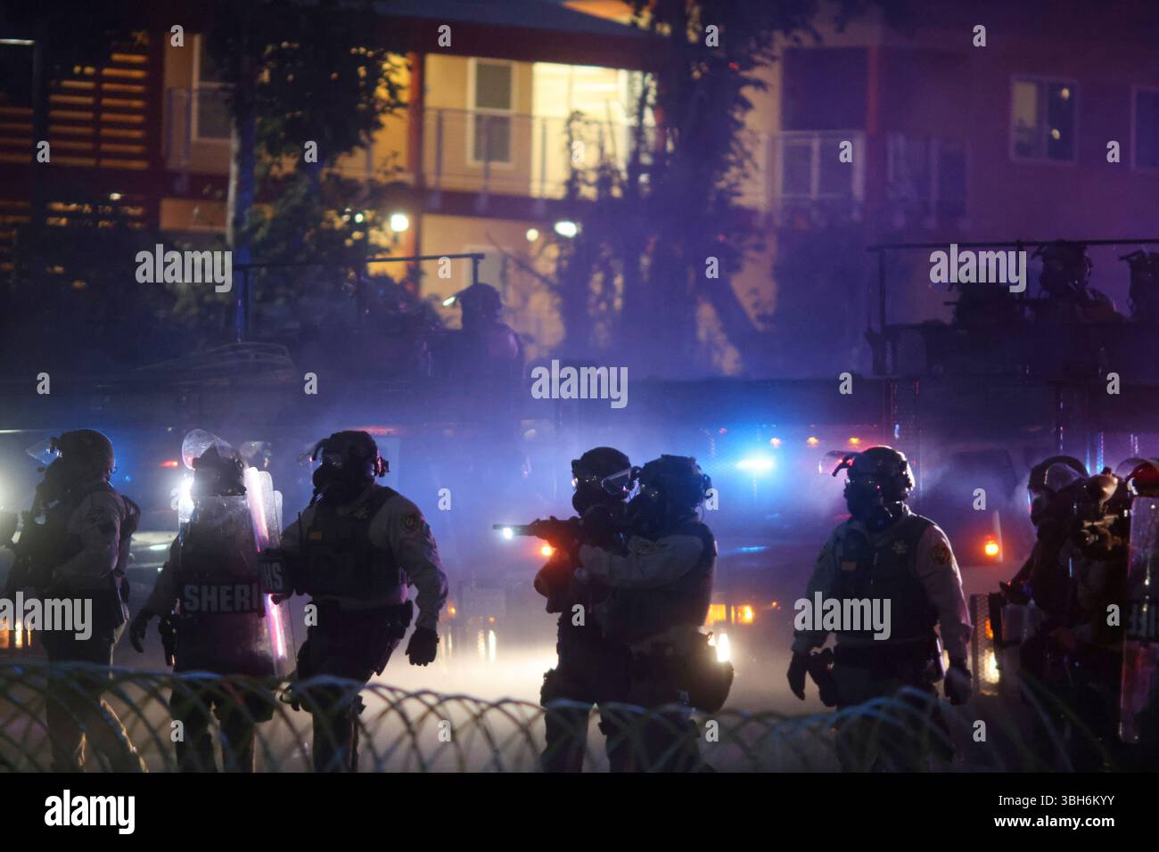 Law enforcement stand during a protest in Compton, Calif., Saturday ...