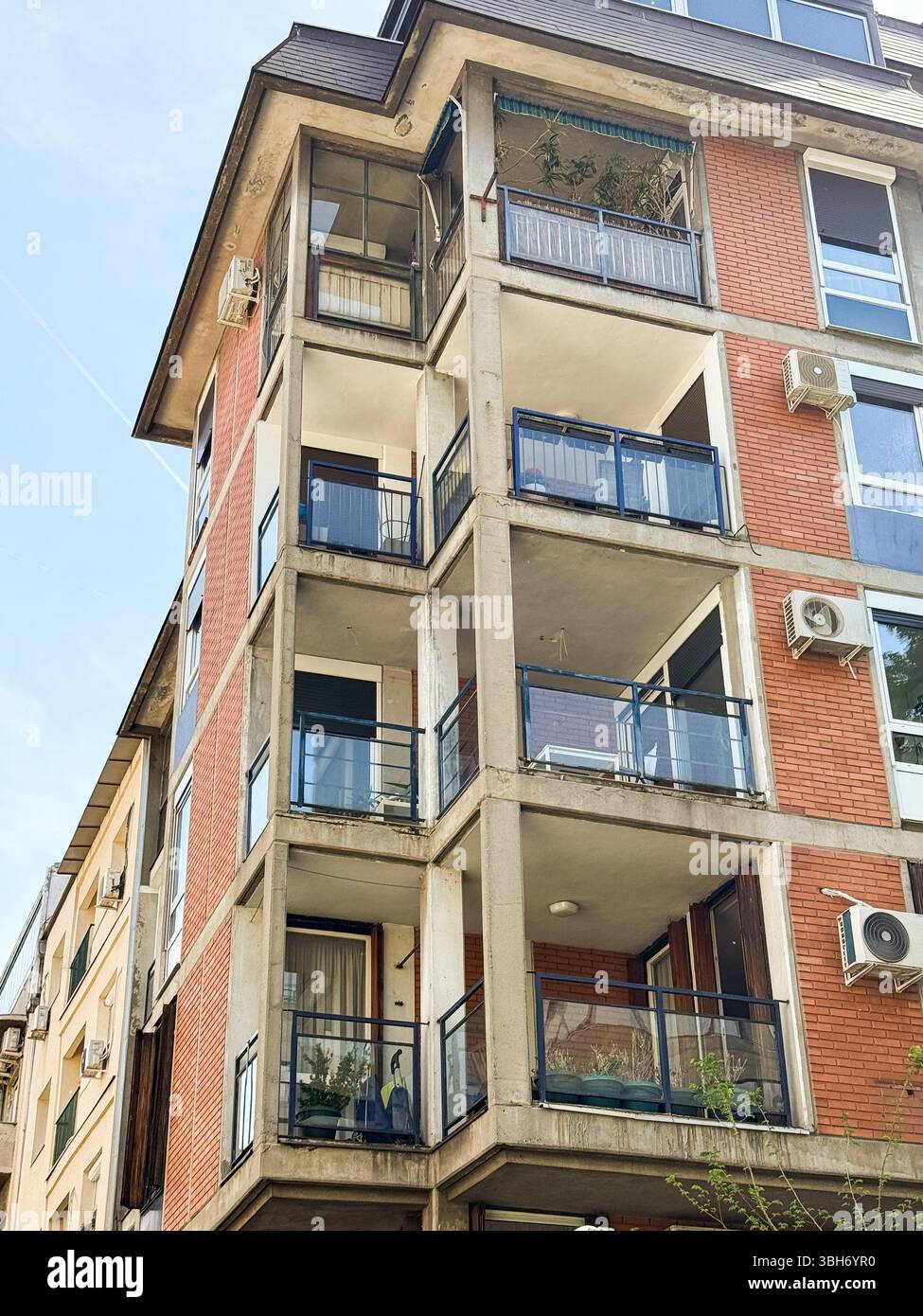Residential building with balconies and red brick facade. Multi-story ...