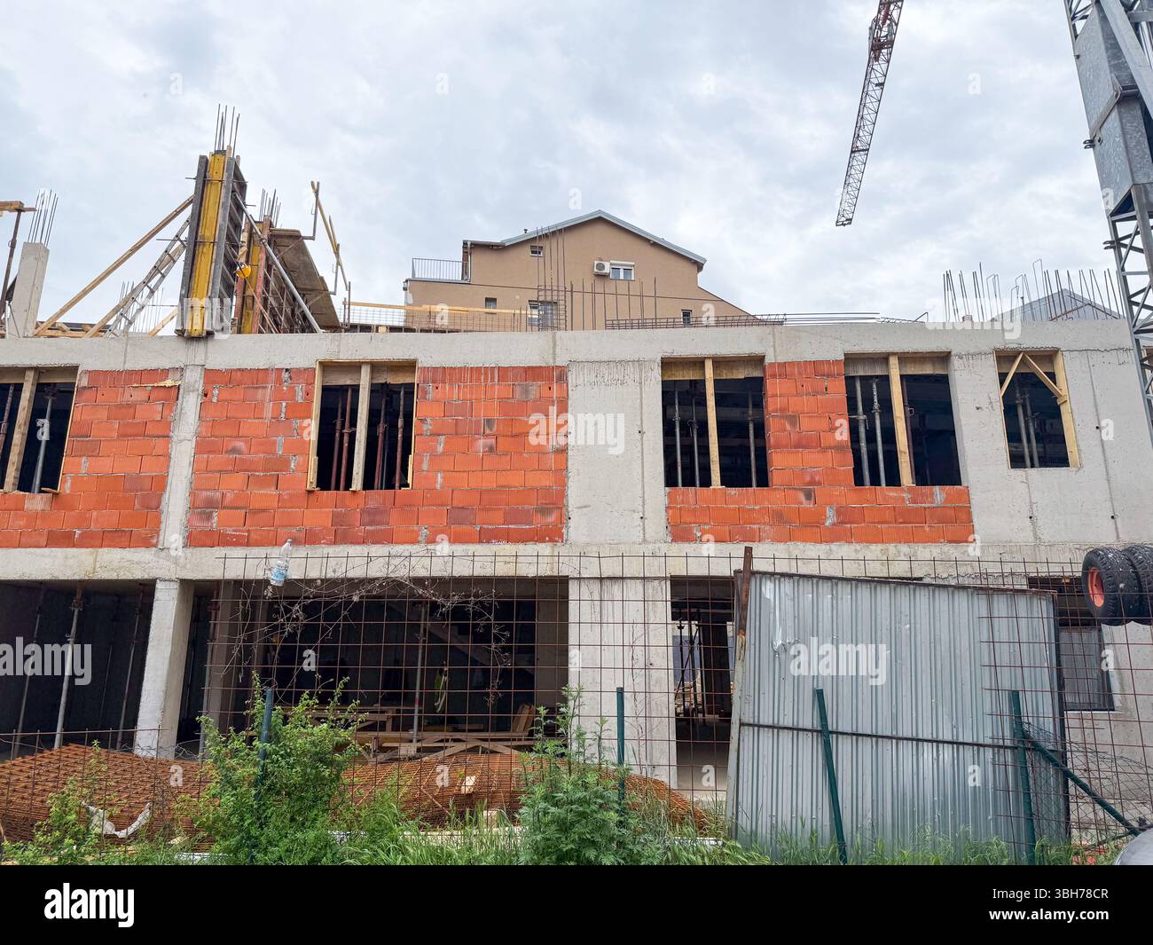 Partially constructed building with exposed red bricks and concrete ...