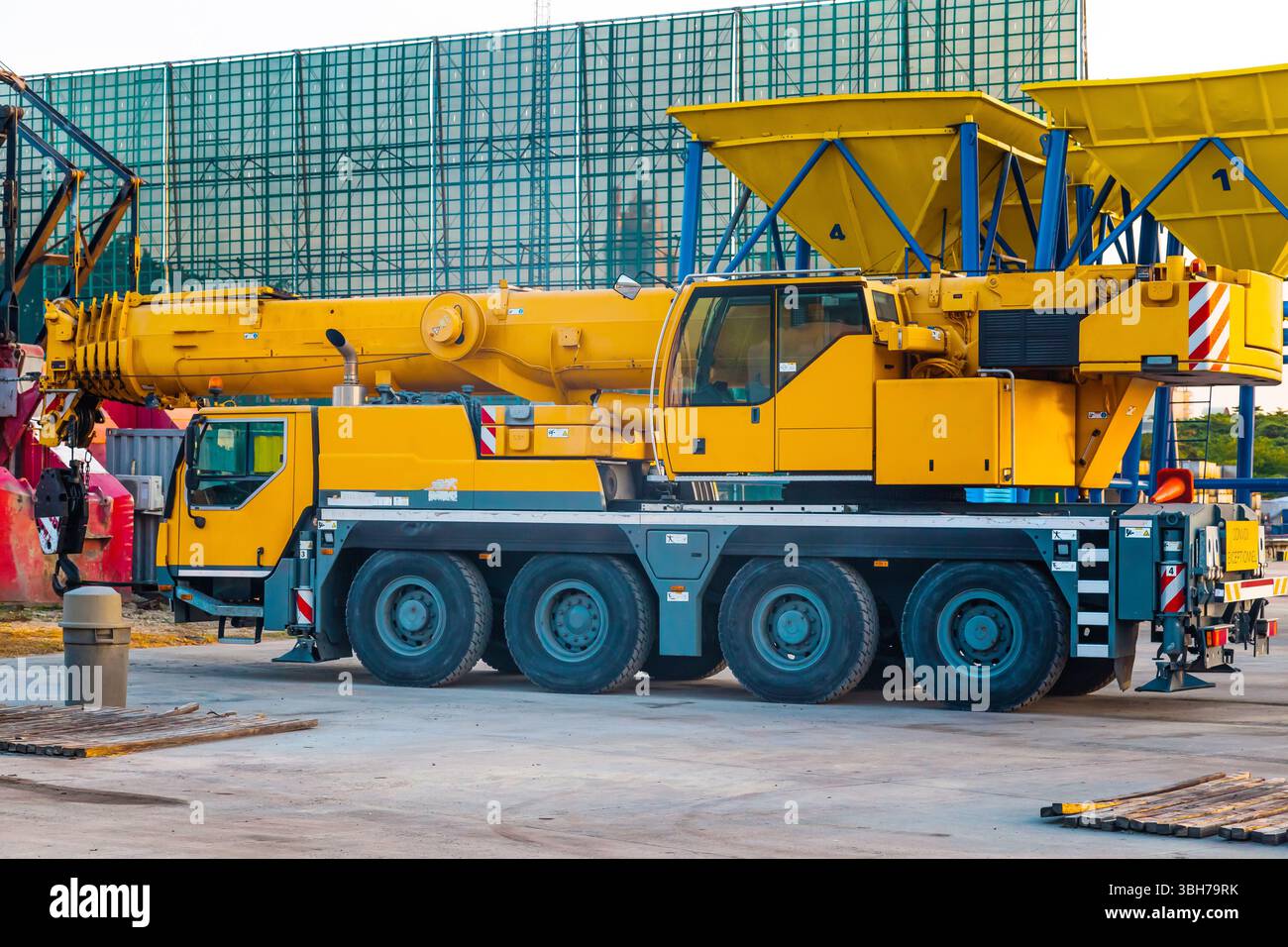 A yellow wheeled truck crane stands in the port. Heavy wheeled loading ...