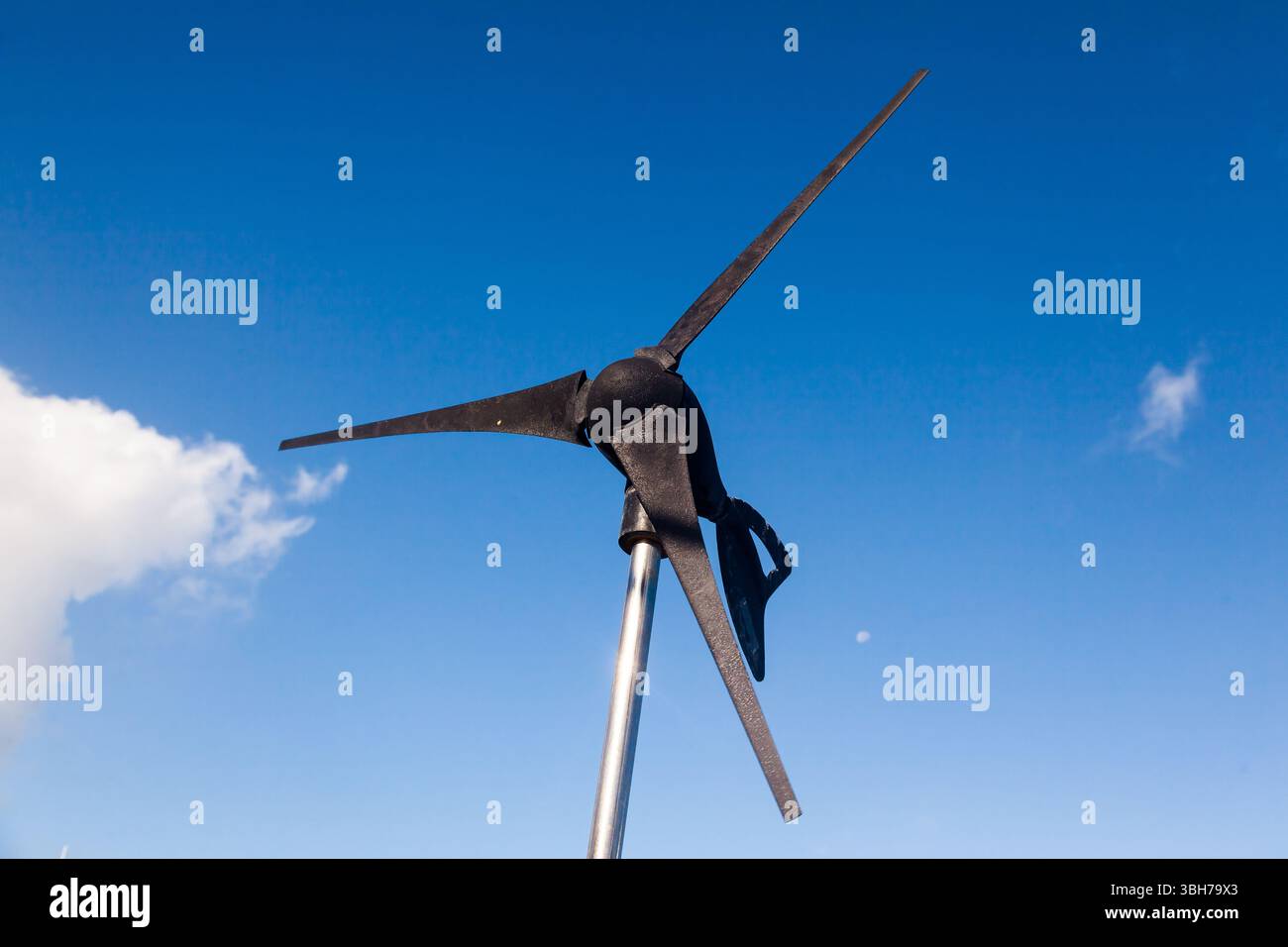 A large weather vane on a steel stand with three rotating blades ...