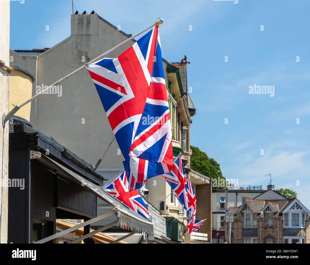 Union Jack flags on shops in street of historic buildings, The Strand ...