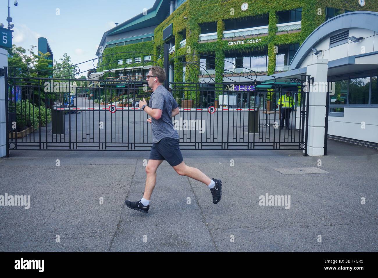 Wimbledon London, UK. 8 June 2025 A jogger runs past the main gate of ...