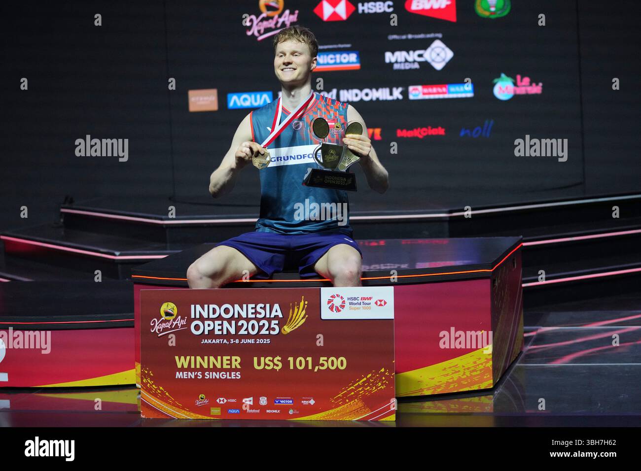 Denmark's Anders Antonsen celebrates on the podium with his trophy ...