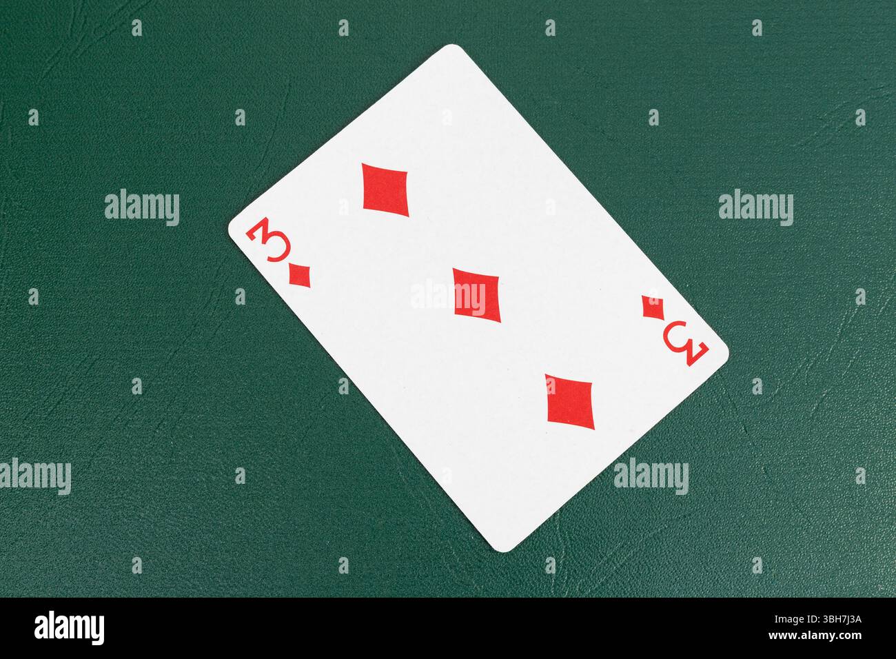 Three of Diamonds Playing Card on Green Table Stock Photo - Alamy