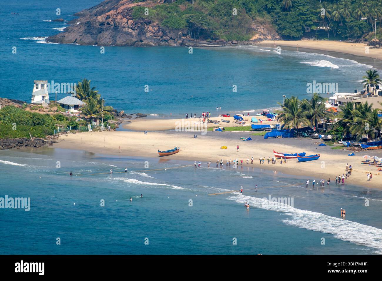 Fishermen haul in a large net by hand on the beach of Kovalam, Kerala ...