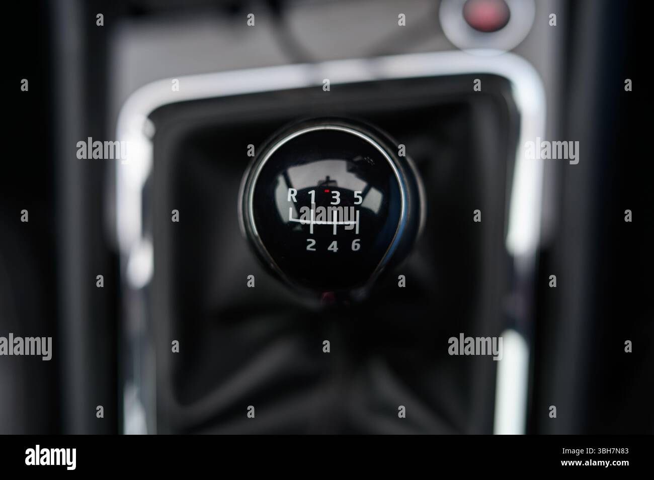 A gear shift with the numbers 1 through 6 on it. The shift is black and ...