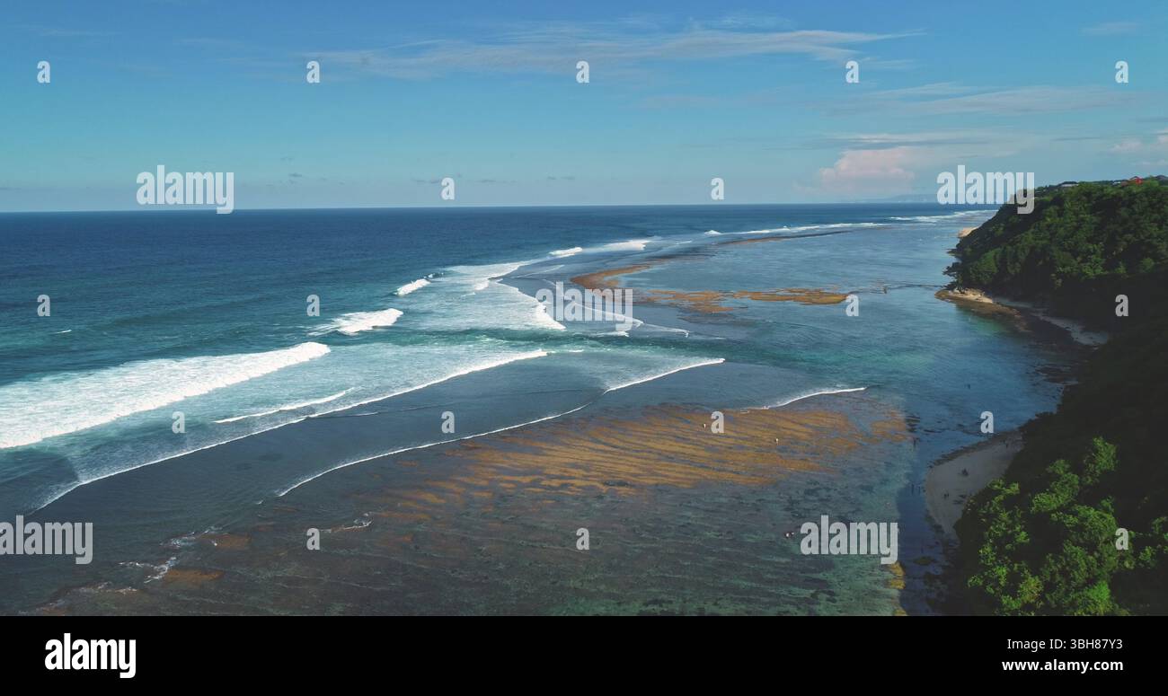 Stunning aerial view capturing waves gently rolling and crashing on ...