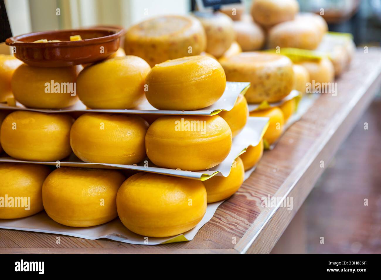 Stacked wheels of Gouda cheese for sale in Amsterdam. This hard cheese ...