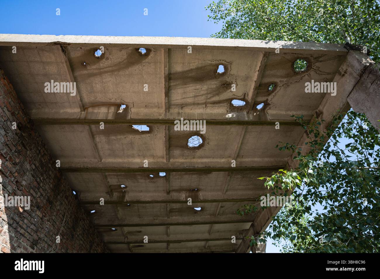 Old concrete ceiling with multiple holes and visible metal ...