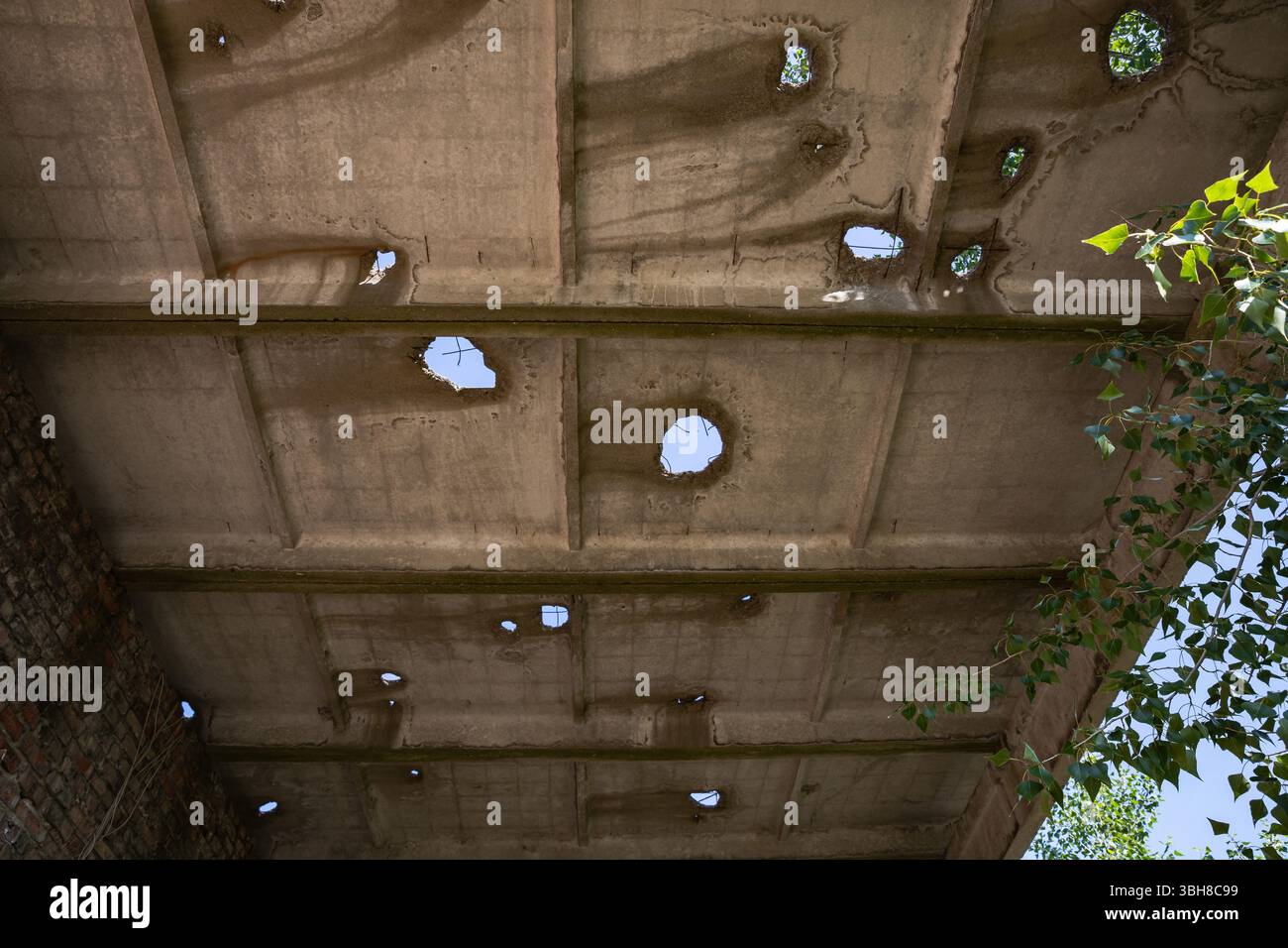 Old concrete ceiling with multiple holes and visible metal ...