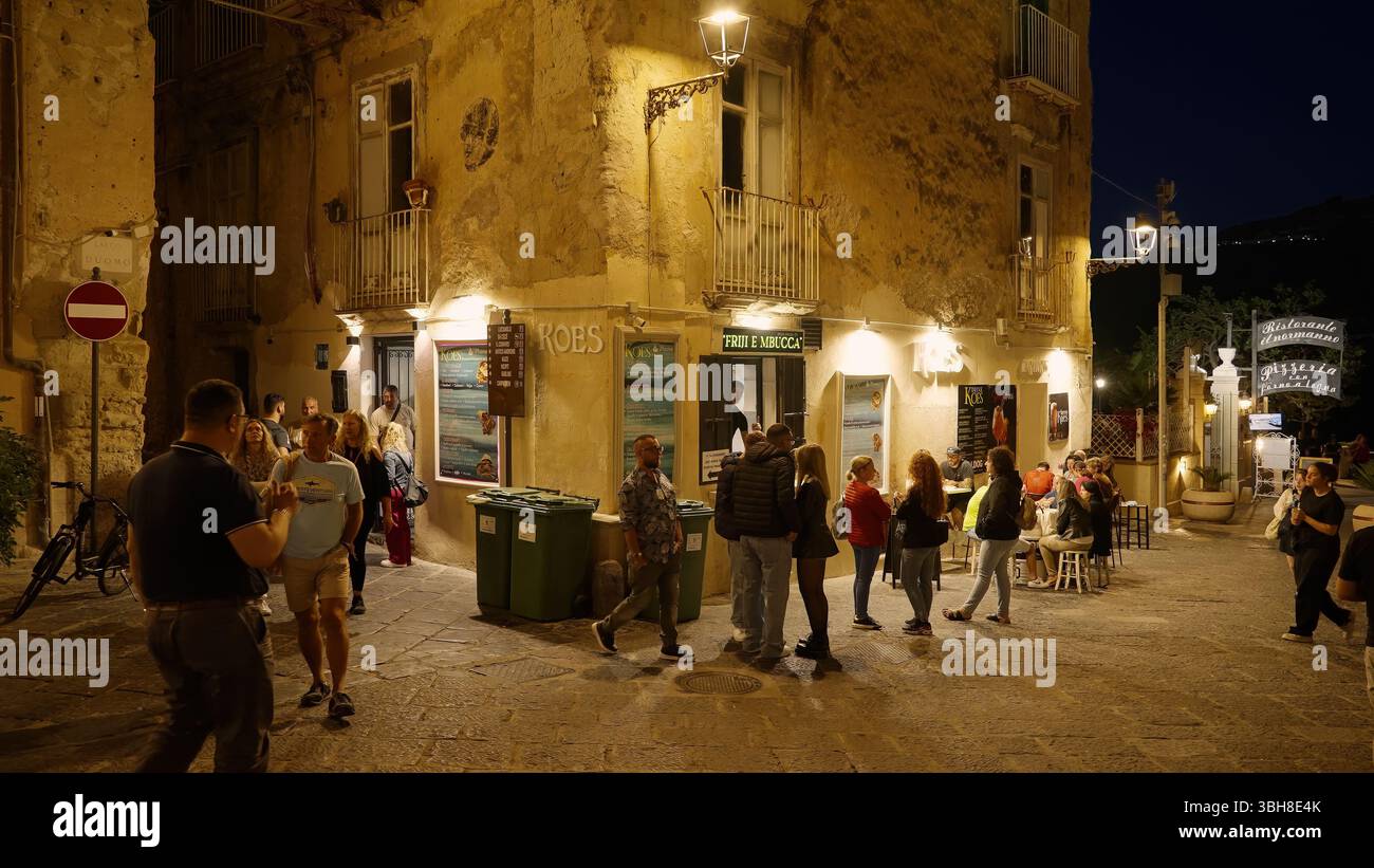 TROPEA, ITALY - JUNE 02, 2025 - Tourists walking and chatting in front of restaurants and bars ...