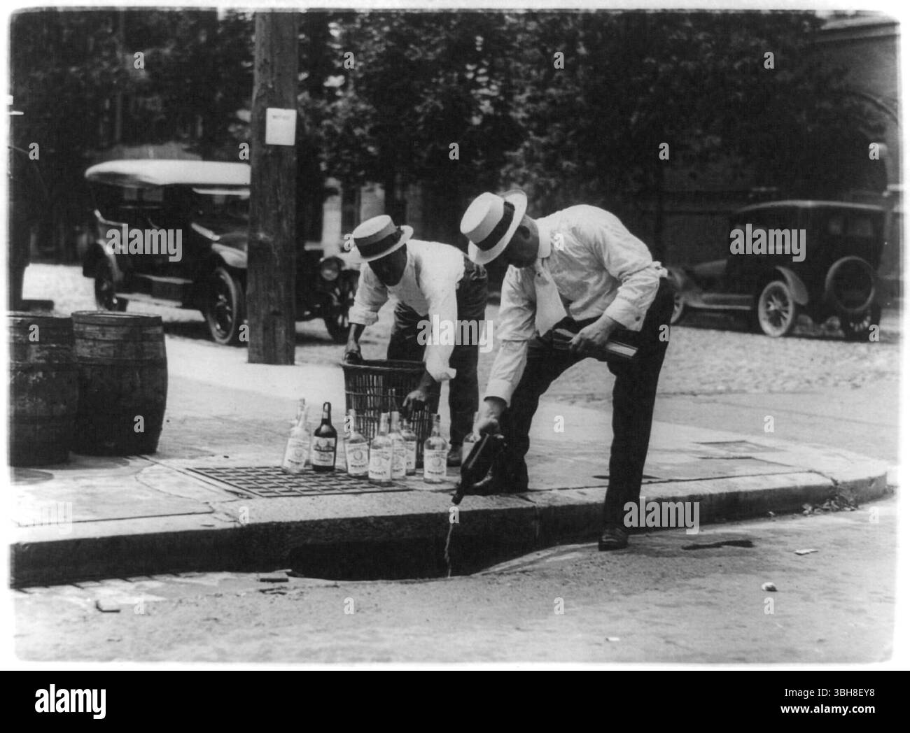 Men pouring bootleg whiskey into a sewer during Prohibition in America ...