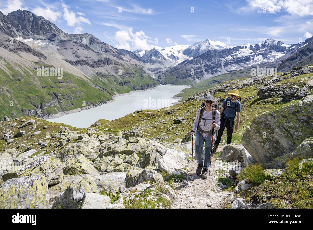 Mountaineer on a hiking trail at a blue mountain lake, reservoir Lac ...