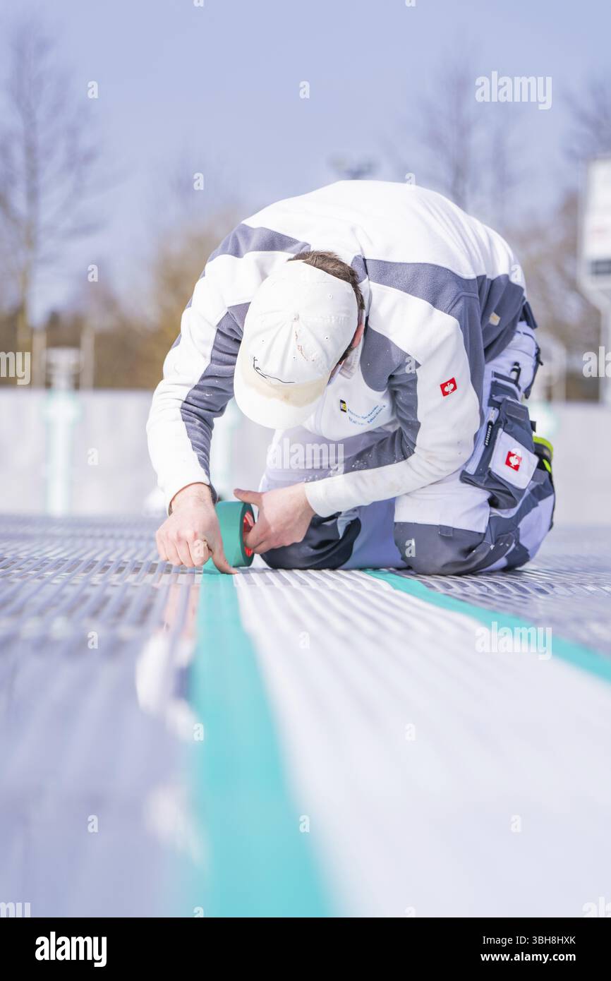 Close-up of a worker applying adhesive tape with a concentrated look on ...