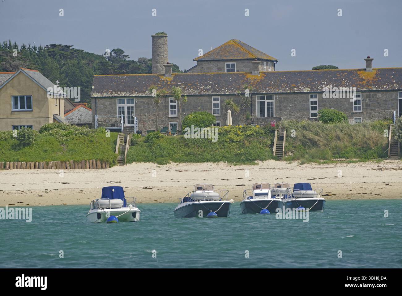 Four small boats close to the beach in front of traditional houses in ...