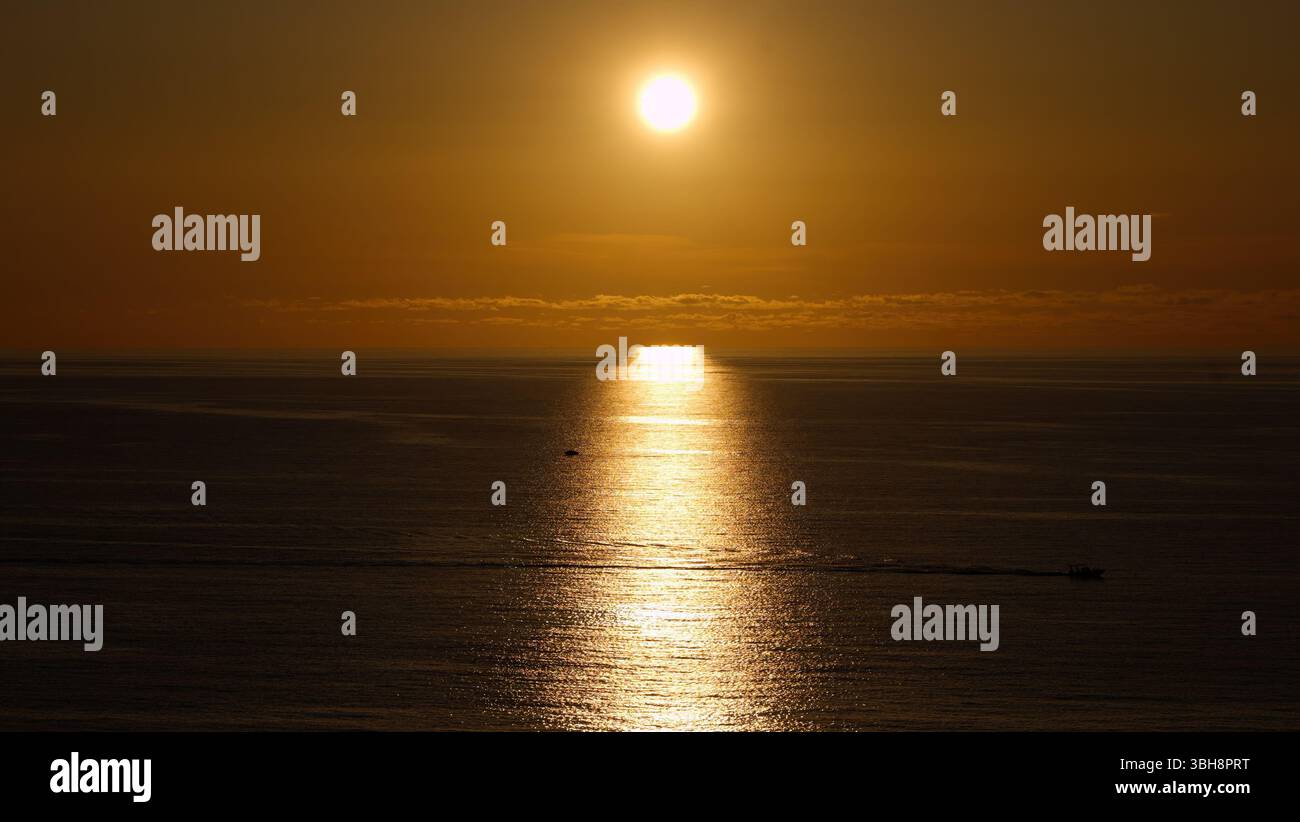 Sun setting over Tyrrhenian Sea reflecting on water surface, creating ...
