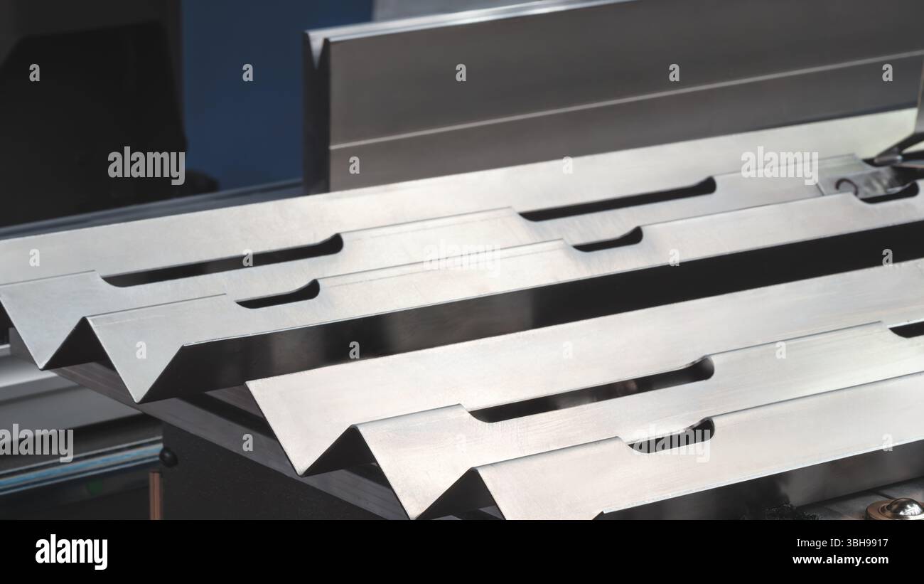 Series of metal pieces are being cut by a machine. pieces are all same ...