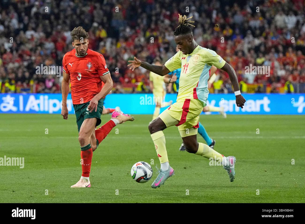 Spain's Nico Williams, right, controls the ball past Portugal's Ruben ...