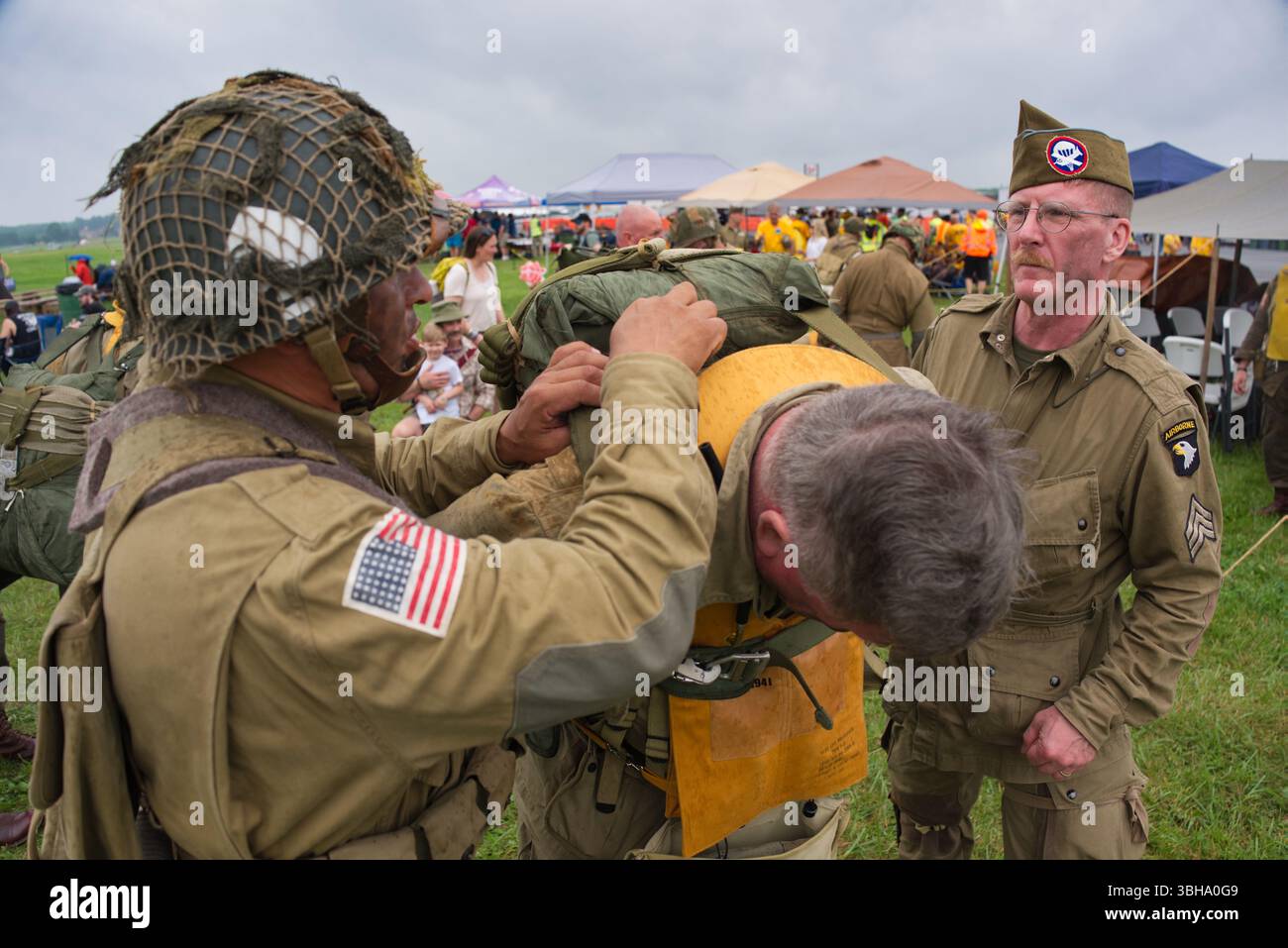 Three men in WWII-era US Army paratrooper uniforms at an outdoor event ...