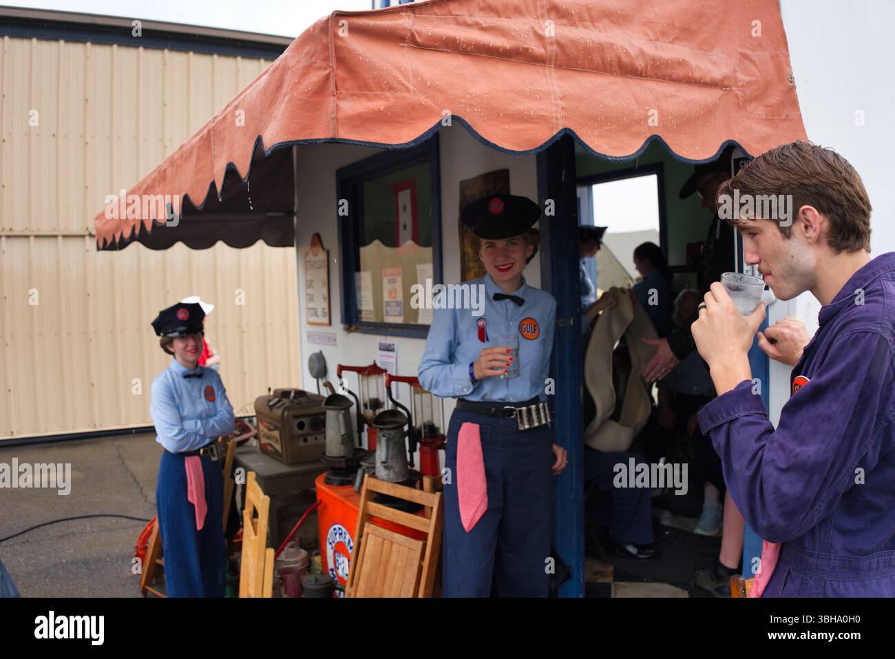 A vintage-style gas station canopy shelters attendants in period ...