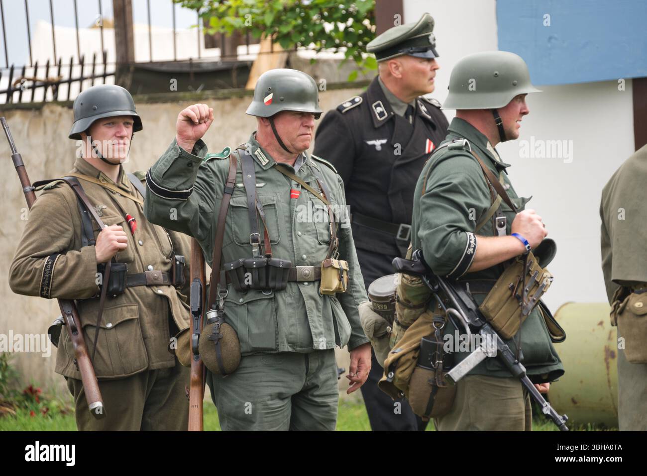 Four men in WWII German military reenactor uniforms, three in field ...