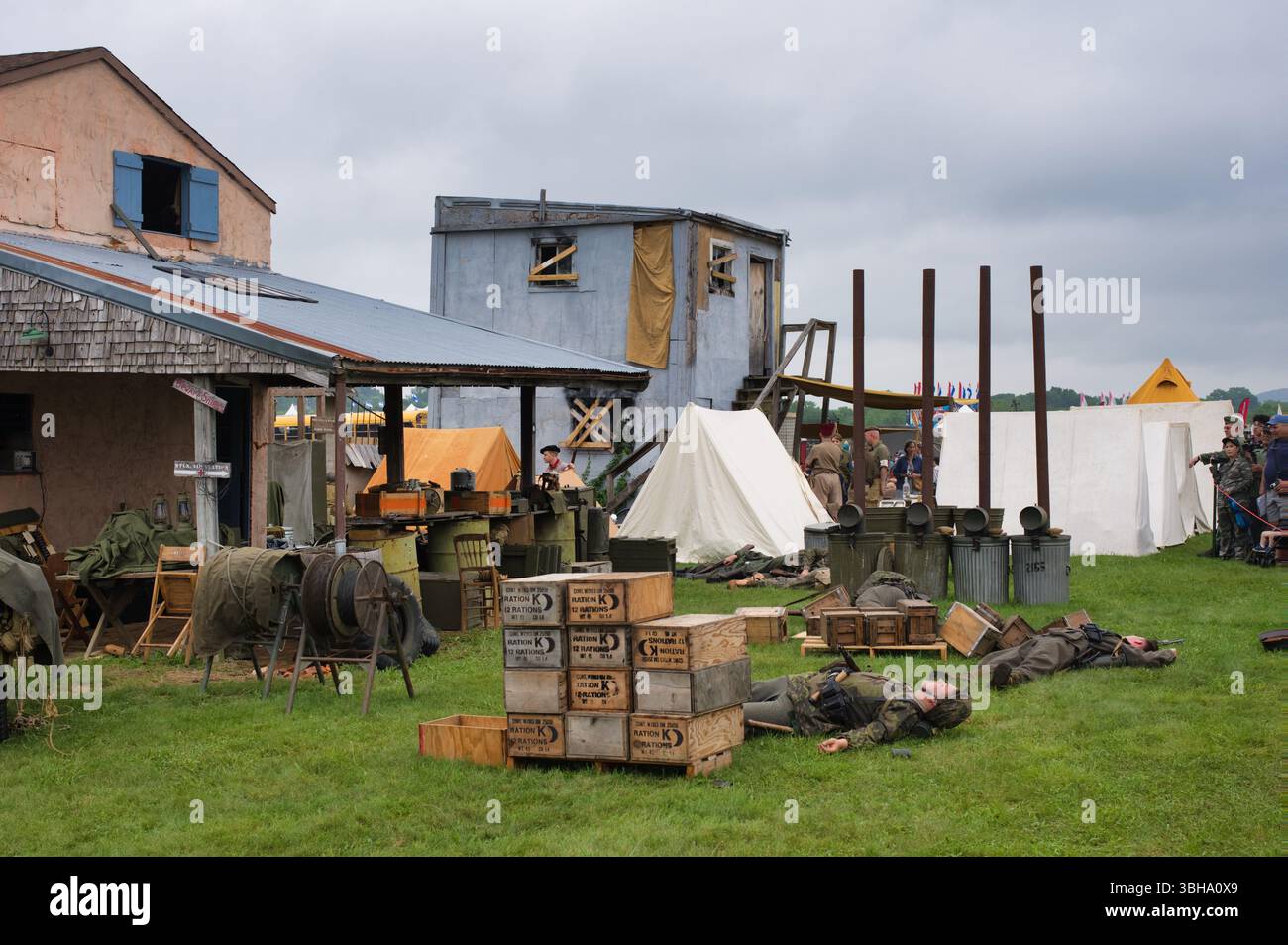 World War II reenactment scene depicting a field camp with buildings ...