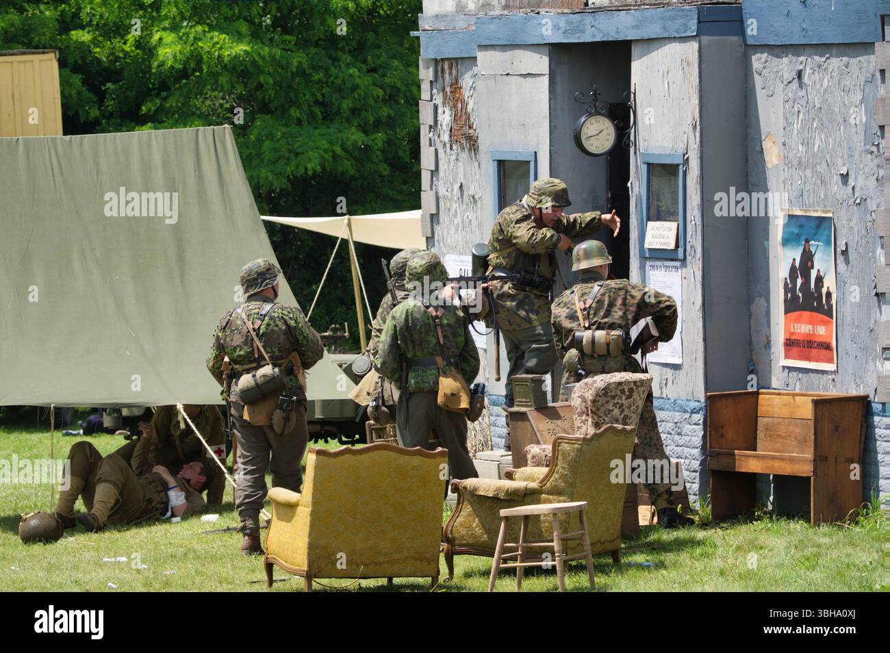 World War II reenactors in German uniforms stage a scene outside a ...
