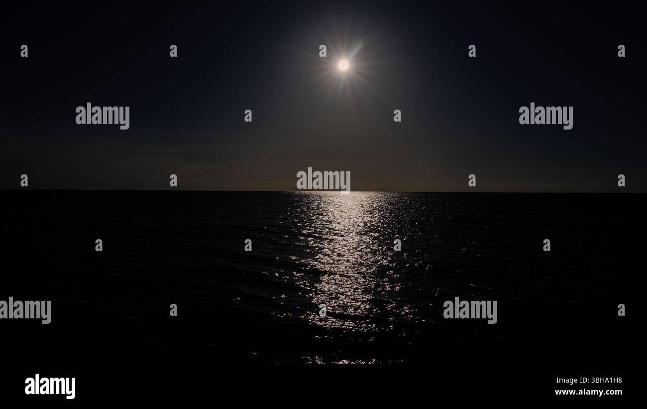 Glimmering reflection of bright star on rippling ocean surface at ...