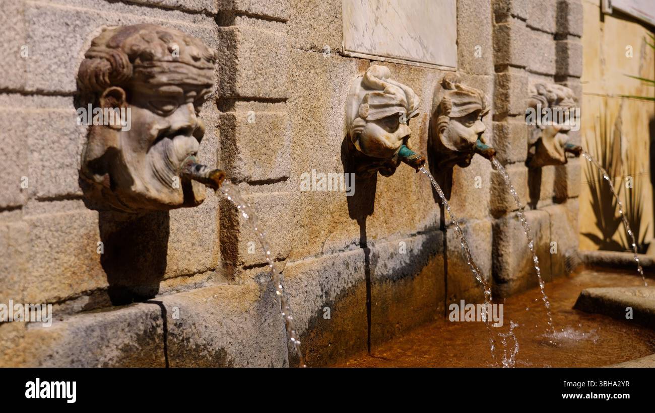 Four gargoyle like sculptures pouring water from their mouth in a ...