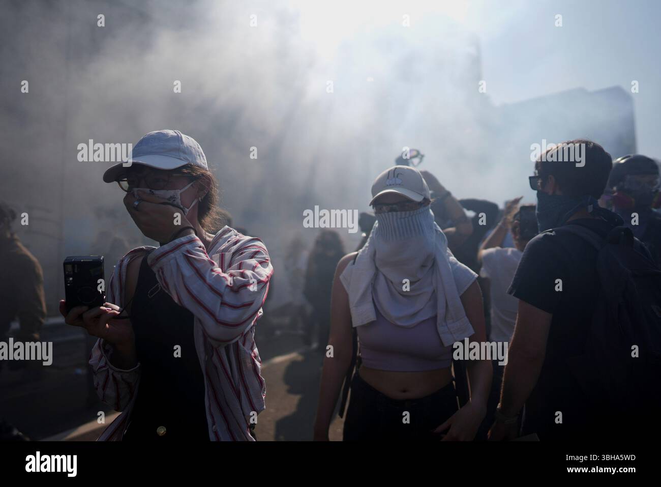 Protesters are seen through smoke on the 101 Freeway near the ...