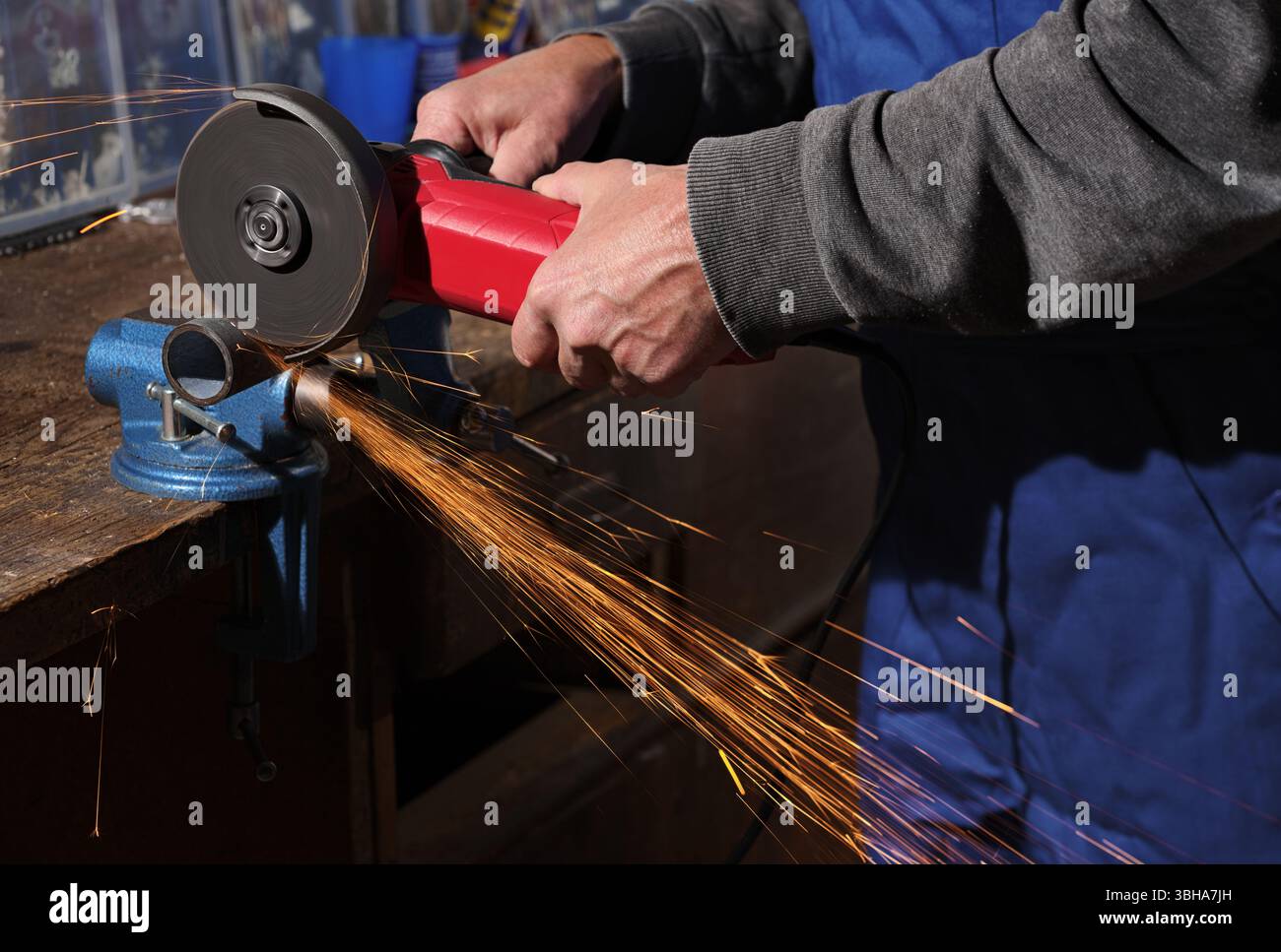 Workman cutting grinding metal pipe with angle disc grind grinder chop ...