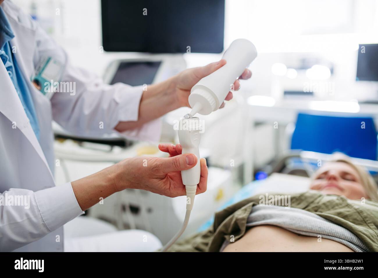 Radiologist applying gel to ultrasound probe before abdominal scan ...