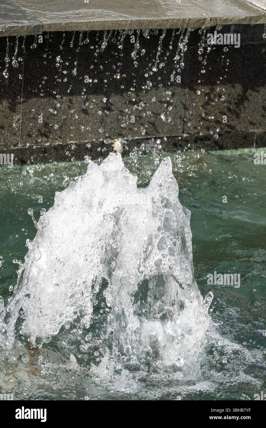 Small stream of water is coming out of a fountain. The water is white ...