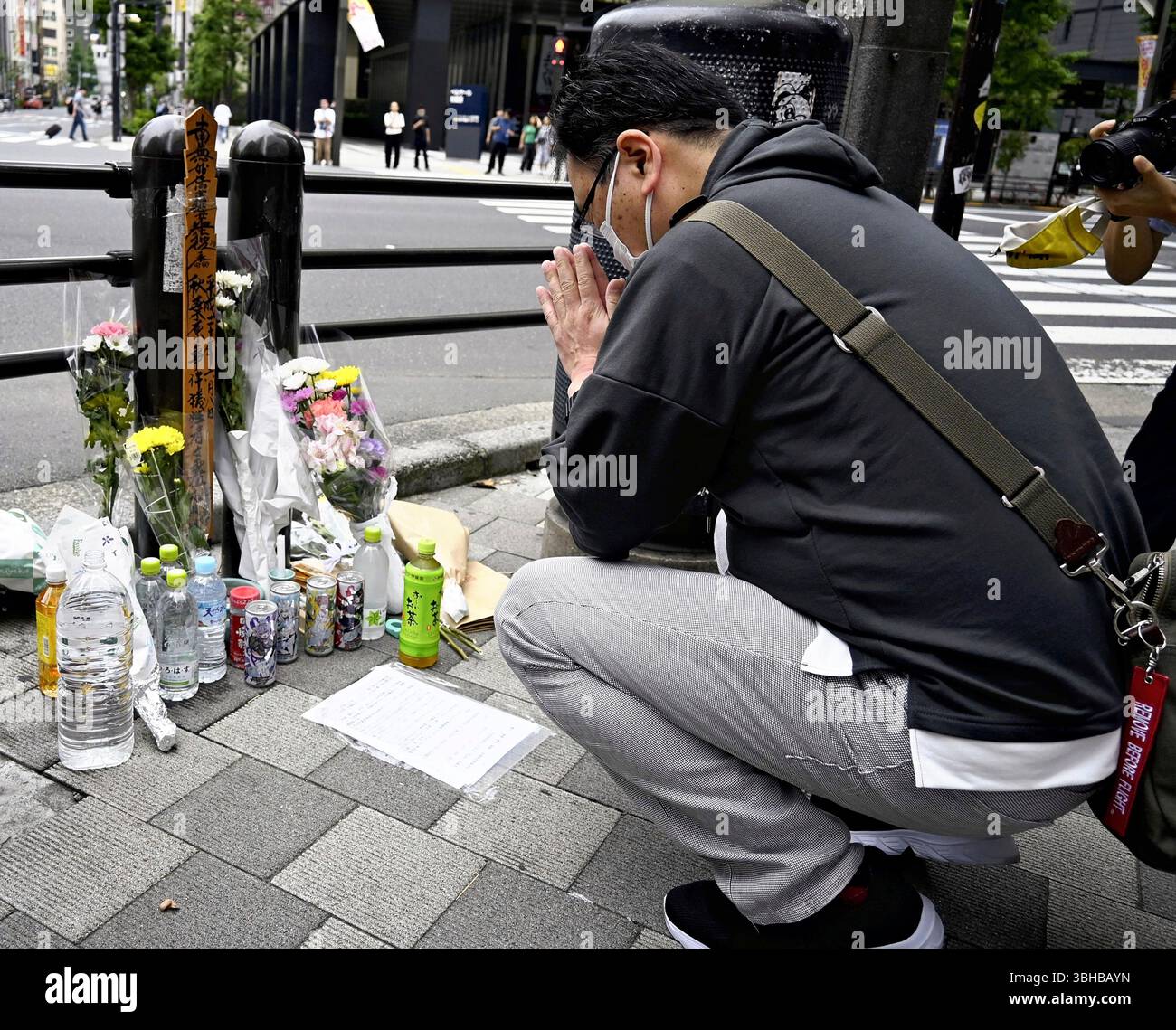 Bunches of flowers are offered in front of the intersection where the ...