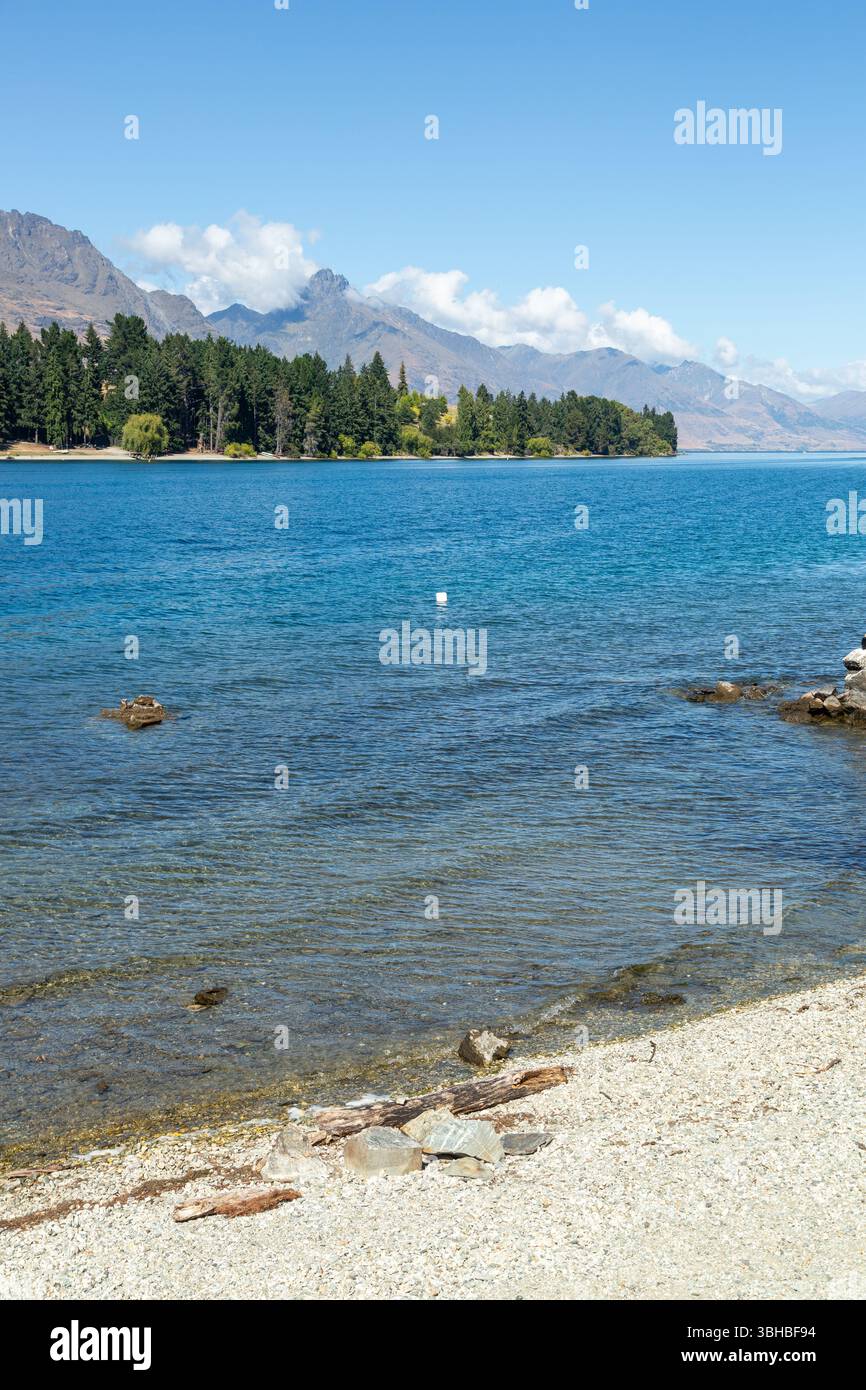 Sunshine Bay Beach on the shores of Lake Wakatipu with mountains in the ...