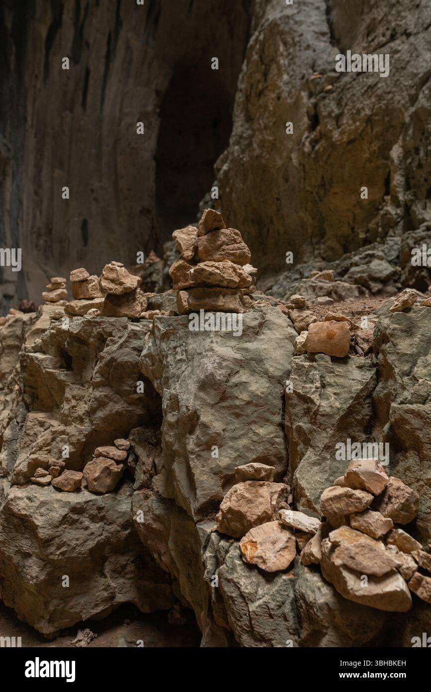 Close-up horizontal composition of stacked stones inside cave with rock ...