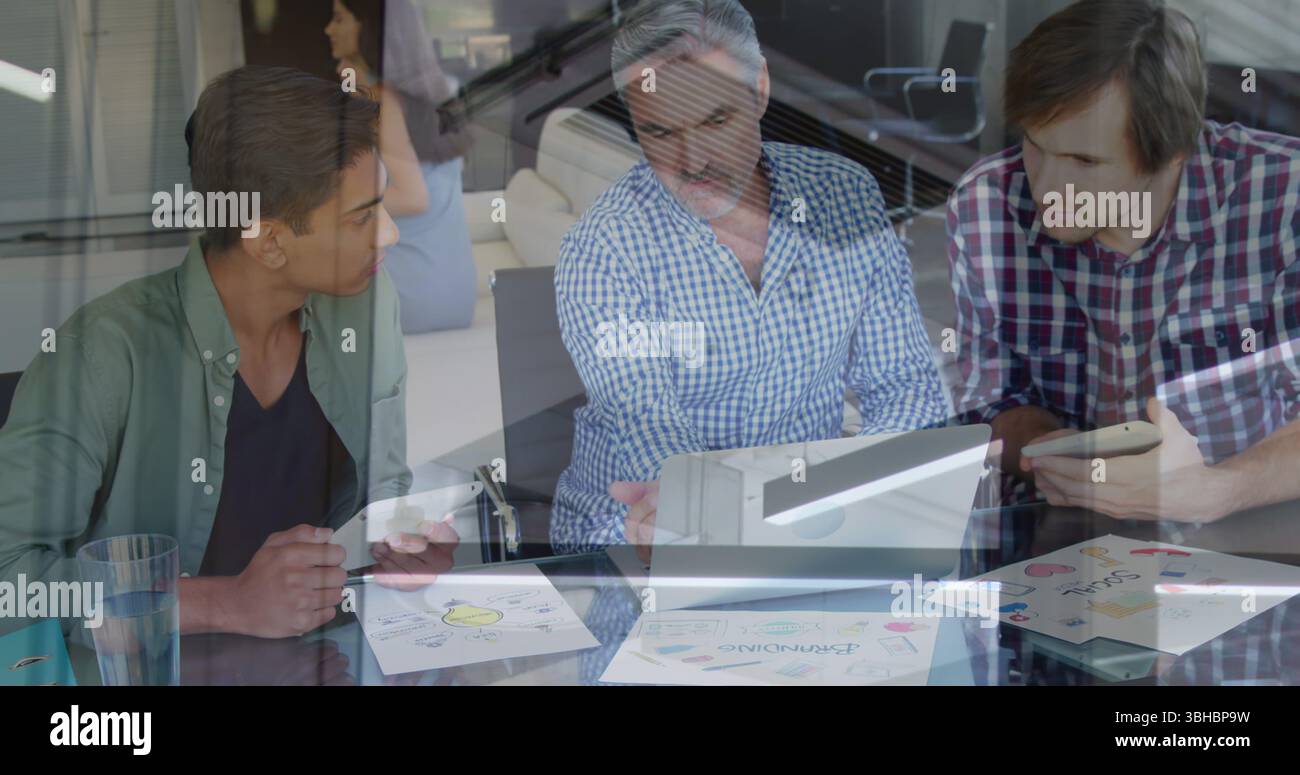 Three colleagues reviewing design sketches in office meeting room, with ...