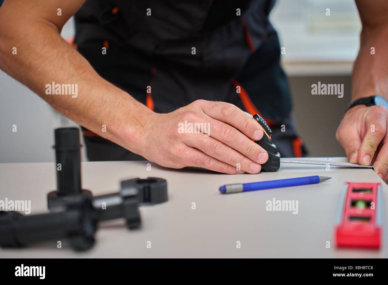 Man measuring furniture part during assembly kitchen cabinets, using ...