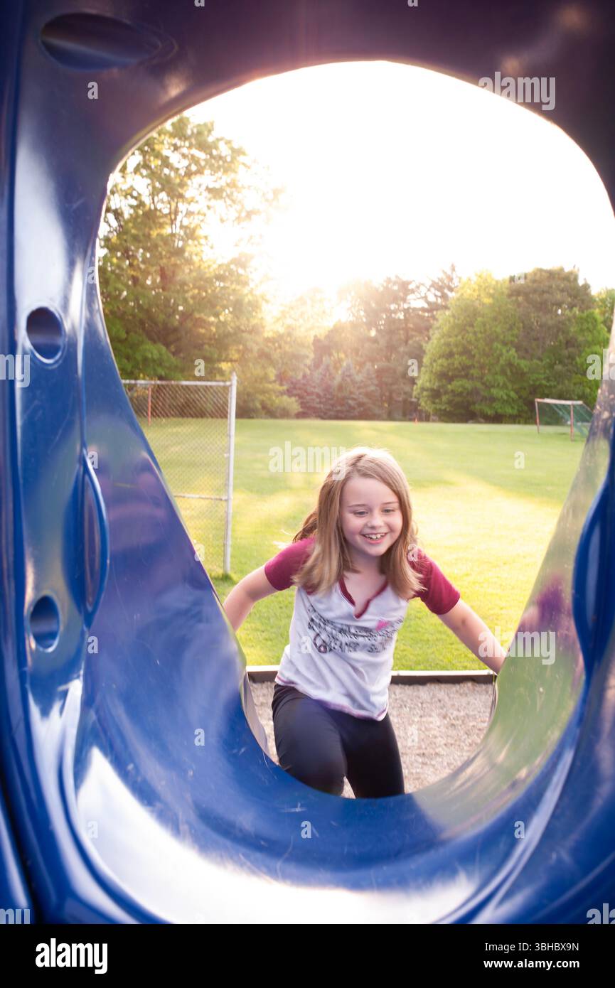 Happy tween girl climbing up sliding board on sunny playground Stock ...