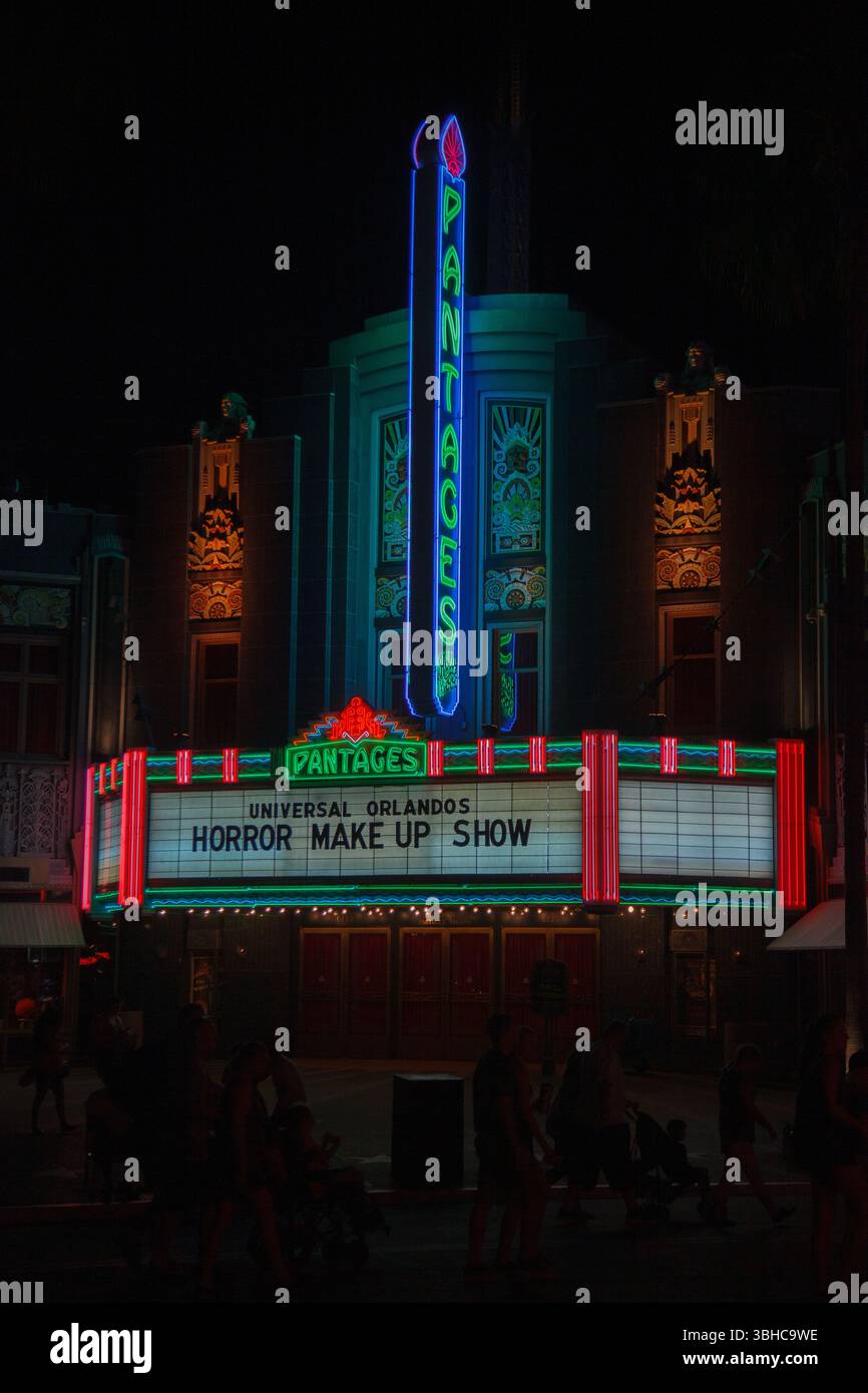 A Typical art deco movie theater facade with neon signs at night in ...