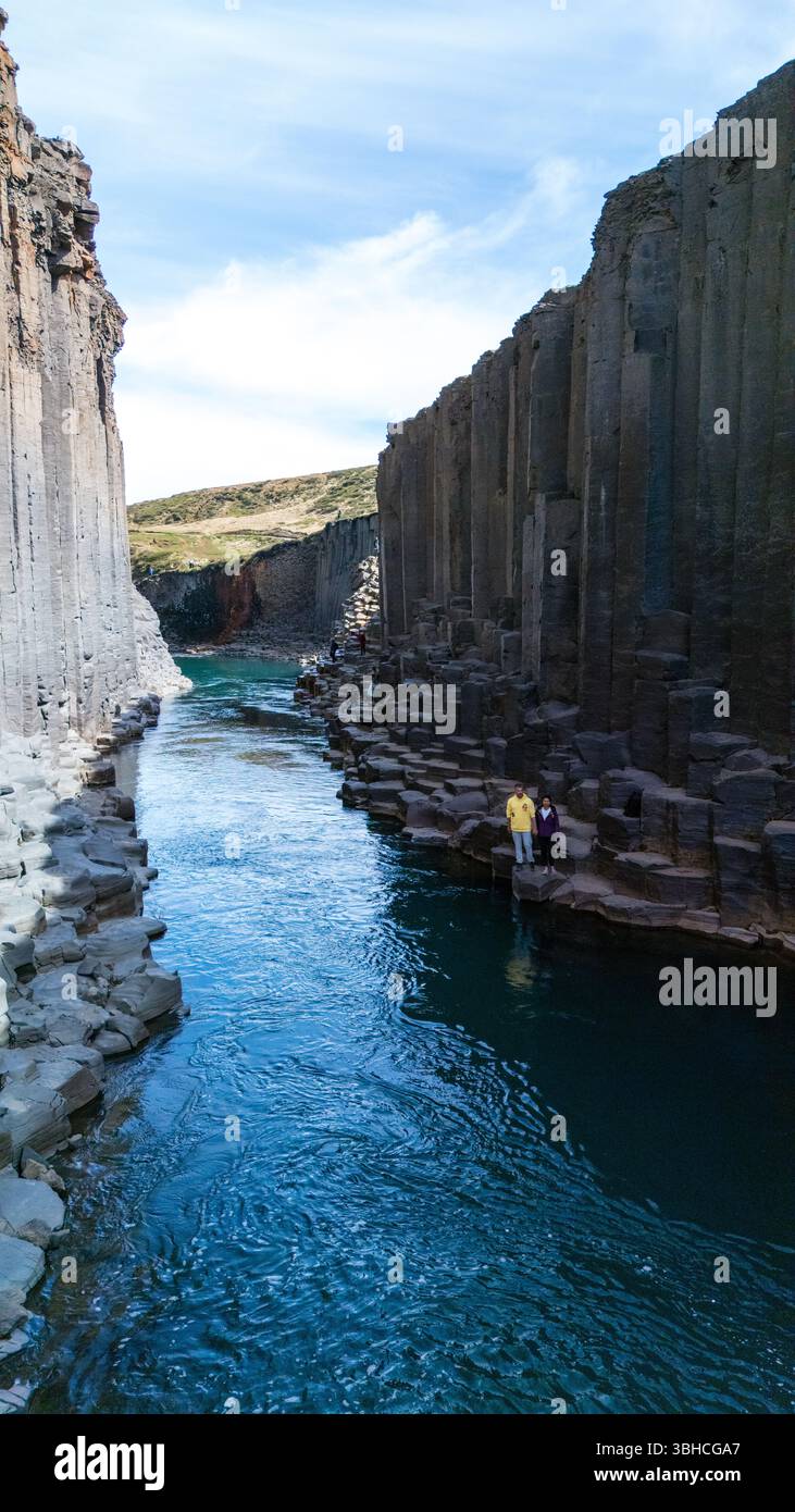 Visitors marvel at the stunning formations of Studlagil Canyon in Iceland, where turquoise ...