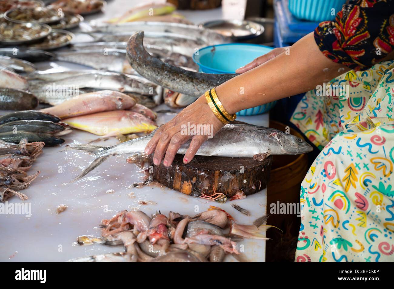 Indian woman cutting fish on a market in Mumbai India, sales stall with ...